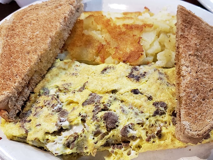 This omelet doesn't just contain cheese and meat—it celebrates them. Nestled between whole wheat toast with home fries playing a delicious supporting role.