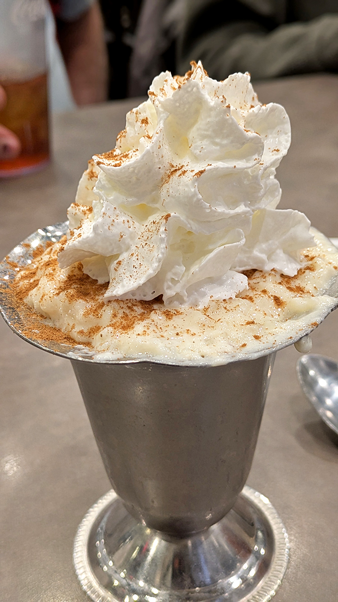 Rice pudding that reaches for the heavens! This towering dessert with its cloud of whipped cream and dusting of cinnamon proves good things come in small metal cups.