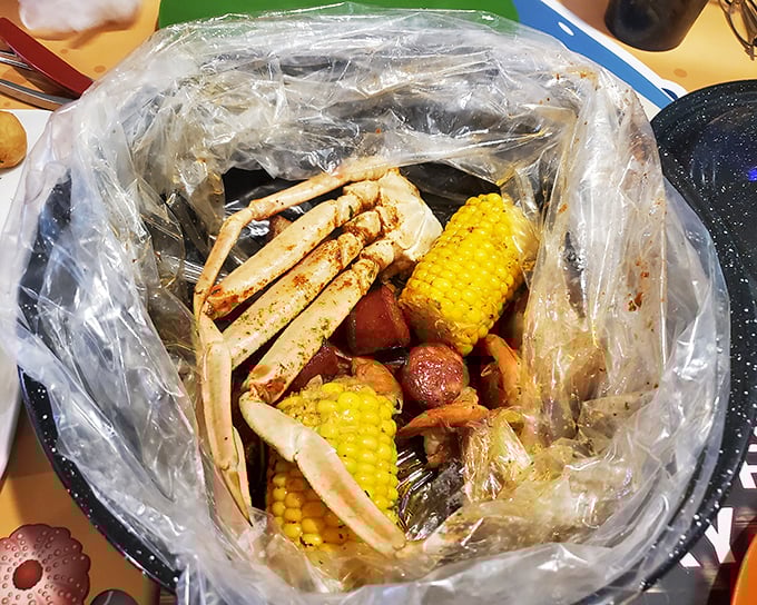 The seafood boil arrives like a treasure chest—snow crab legs, corn, and potatoes swimming in seasoned glory. Roll up your sleeves, this gets personal.