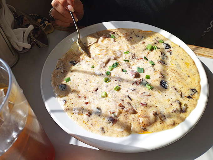 The legendary shrimp and grits—creamy, cheesy perfection studded with plump shrimp and bacon, garnished with green onions for that perfect finish.