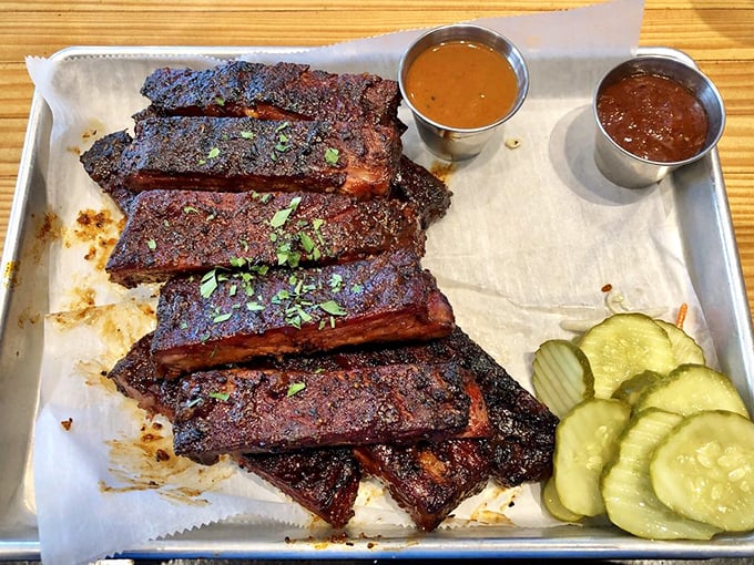 St. Louis ribs glazed to mahogany perfection, served with pickles and sauces for the ultimate barbecue experience.