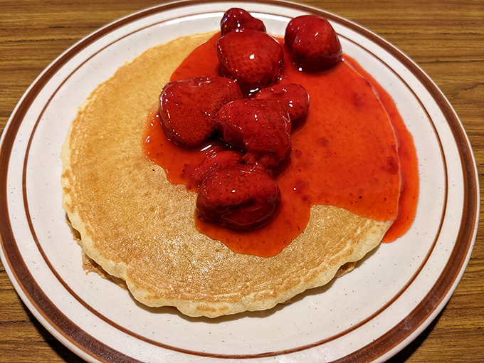 This isn't just a pancake – it's a canvas for berry brilliance. The strawberry topping adds that perfect sweet tang to morning indulgence.