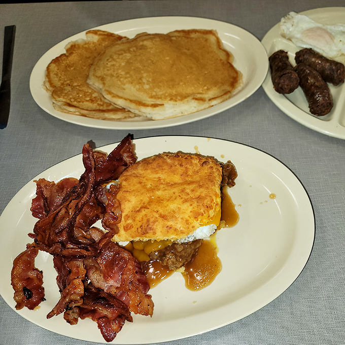 Southern breakfast architecture at its finest—a monument to gravy engineering with crispy bacon sentries standing watch.