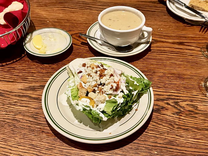 The wedge salad—that beautiful dinosaur of steakhouse appetizers—stands proud with blue cheese crumbles playing hide and seek among the greens.