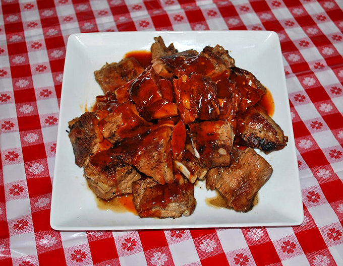 Ribs glistening with sauce that should have their own ZIP code. The kind worth wearing a bib for.