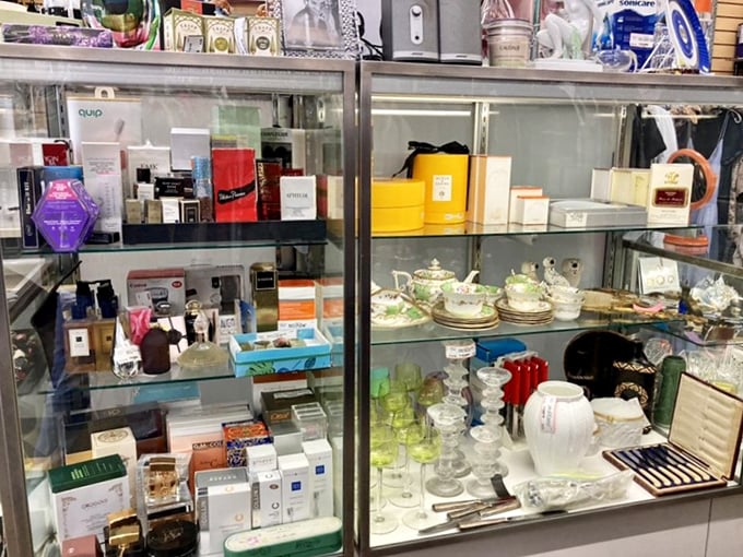 A glass case shrine to luxury beauty and collectibles—proof that someone's decluttering crisis has become your vanity's jackpot.