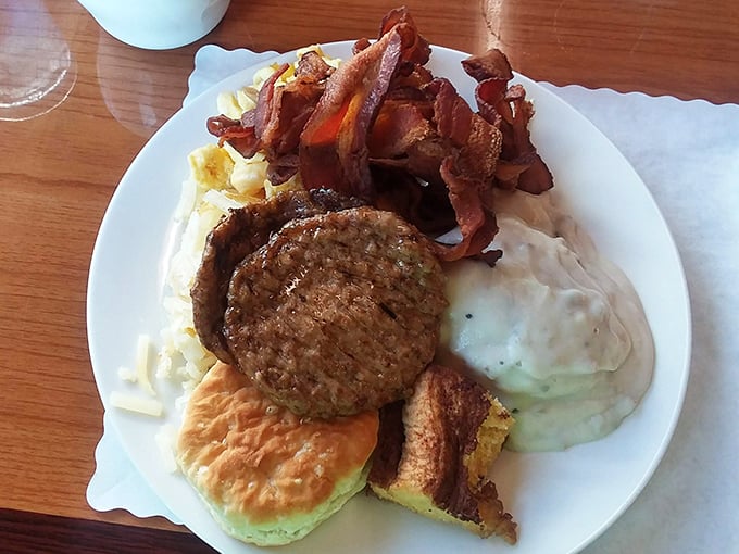 A breakfast plate that doesn't mess around – meat, eggs, gravy, and a biscuit standing at attention like delicious soldiers ready for duty.