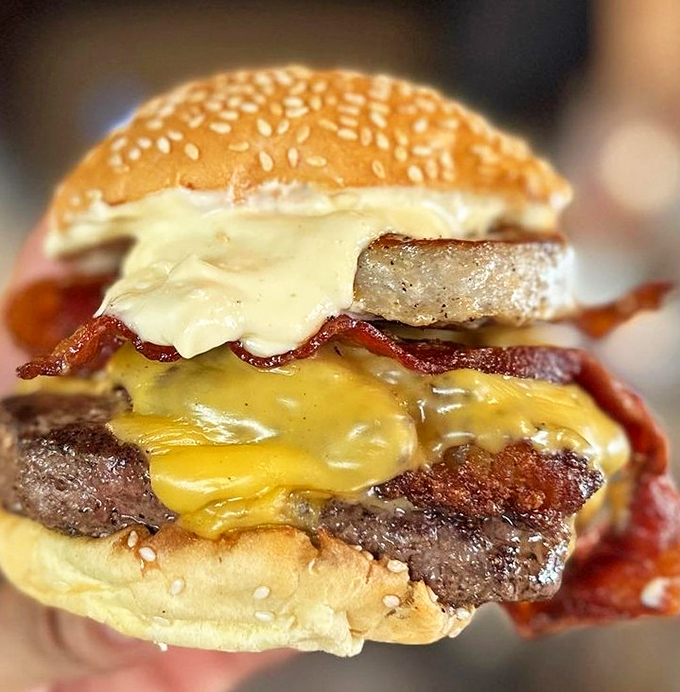This isn't just a burger—it's architecture. The melted cheese cascading down the sides like delicious lava makes resistance utterly futile.