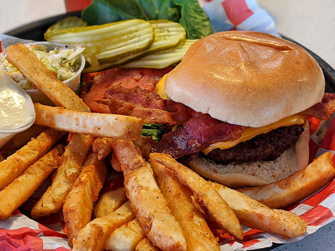 This isn't just a burger – it's architecture. A towering achievement of beef, bacon, and cheese flanked by crispy fry sentinels.