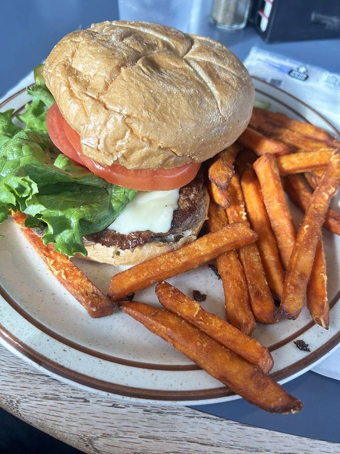 Behold the burger that launched a thousand napkins! Those sweet potato fries aren't sidekicks – they're co-stars in this lunchtime drama.