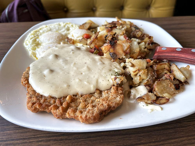 Chicken fried steak smothered in country gravy alongside eggs and those legendary potatoes – the breakfast trifecta that makes mornings worth facing.