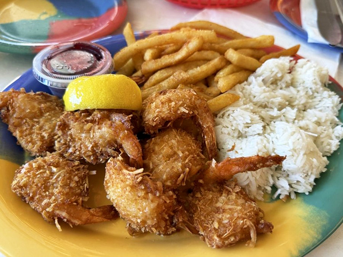 Coconut shrimp that would make Tom Hanks' Castaway character weep with joy—golden-crisp outsides giving way to tender seafood, with rice and fries as worthy companions.