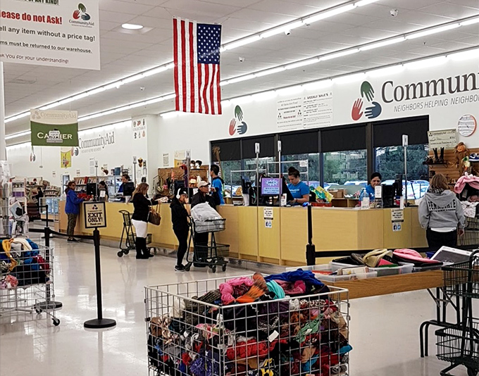 The checkout area—where American flags hang proudly and yellow counters welcome shoppers whose carts contain someone else's memories and their own new possibilities.
