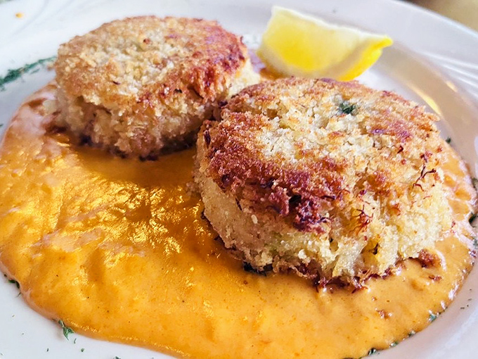 These crab cakes don't mess around—golden-crisp exteriors giving way to sweet, tender crab meat atop a sunset-colored sauce.