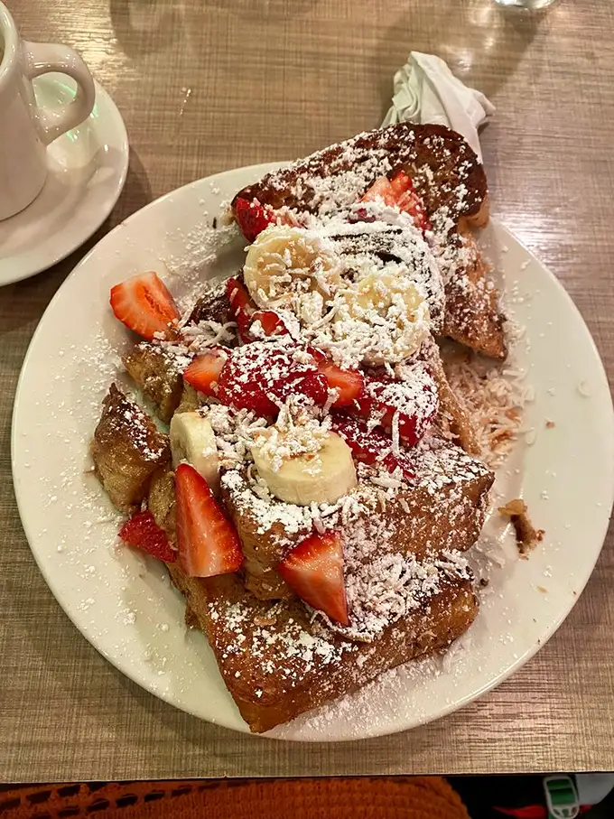 French toast that makes ordinary bread feel inadequate. Those fresh strawberries and bananas are trying to make this indulgence seem healthy—don't be fooled.