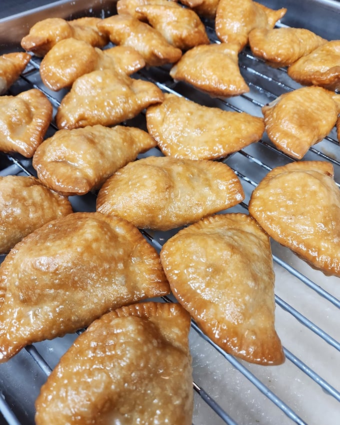Golden fry pies cooling on the rack—crisp, glistening pastry pockets waiting to deliver their sweet filling straight to your happiness center.
