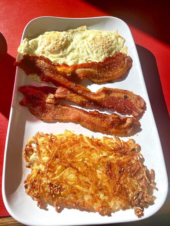 The breakfast trinity: perfectly crisp bacon, eggs with sunshine-yellow yolks, and hash browns with the ideal crisp-to-tender ratio. Diner nirvana achieved.