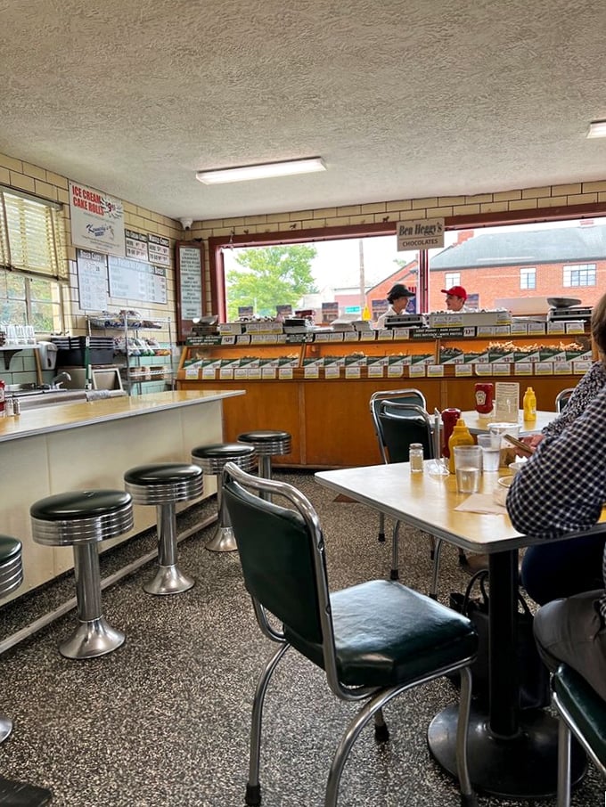 Those chrome stools aren't just seating—they're front-row tickets to the greatest ice cream show on earth. The candy counter beckons beyond..
