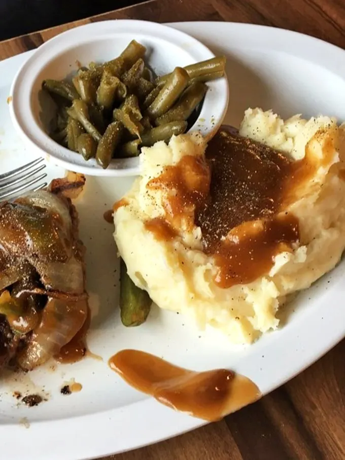 These mashed potatoes and green beans aren't just sides—they're supporting actors that deserve their own Oscar. The gravy river makes everything better.