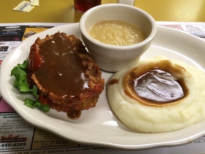 The legendary meatloaf in its natural habitat, surrounded by mashed potatoes and green beans. This is what food dreams are made of.