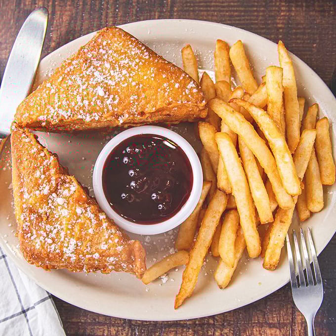The Monte Cristo: deep-fried, dusted with powdered sugar, and served with raspberry sauce. Proof that sometimes the best relationships are sweet and savory.