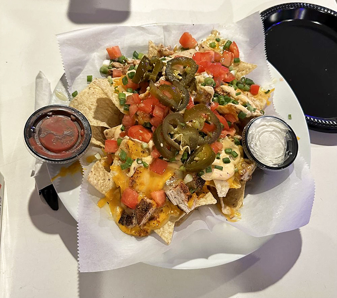 The nacho mothership has landed – a glorious mess of cheese, jalapeños, and toppings that demands to be shared but tempts you not to.