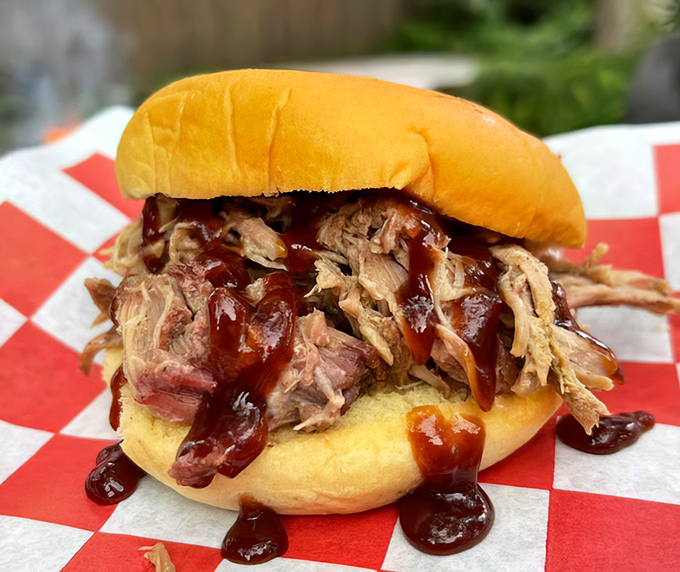 The legendary pulled pork sandwich—a mountain of smoky, tender meat that's had a meaningful relationship with wood smoke before meeting its soulmate: that soft bun.