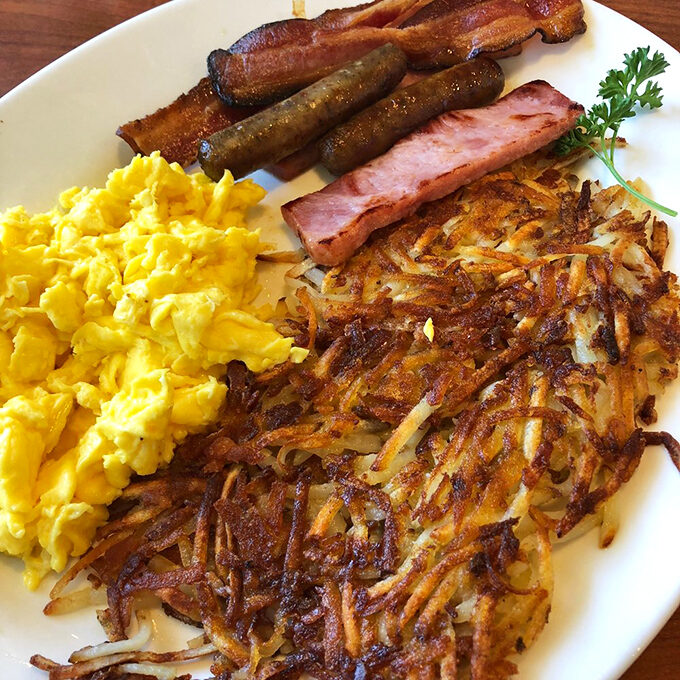 The holy trinity of breakfast: crispy hash browns, perfectly cooked eggs, and sausage links that mean business.