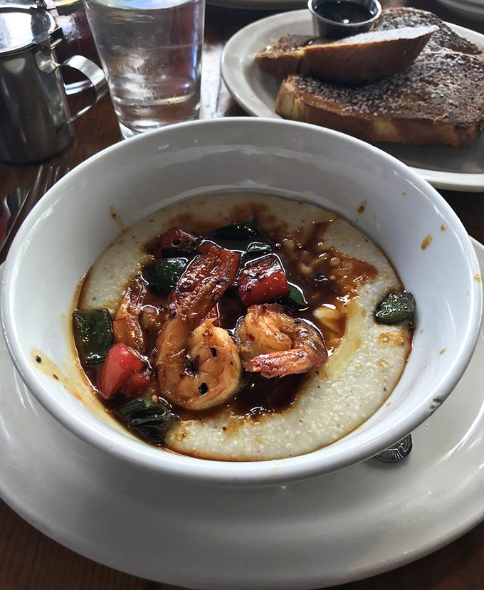 Shrimp and grits elevated to an art form. Those plump crustaceans lounging on creamy cornmeal are having a better morning than most humans.