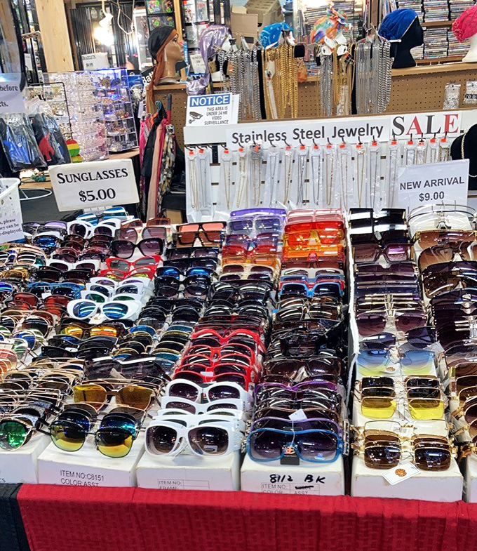 The sunglasses display—where everyone tries on ten pairs but photographs themselves in only one. Five dollars buys you instant cool or magnificent regret.