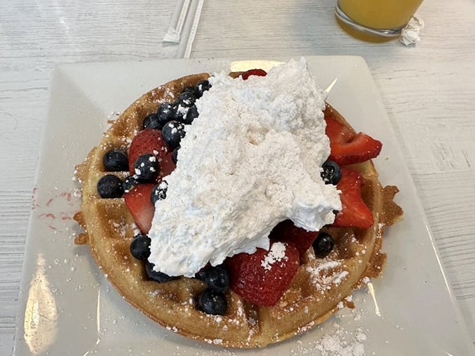 A waffle that's dressed for success with berries, whipped cream, and powdered sugar. Breakfast or dessert? The correct answer is "yes."
