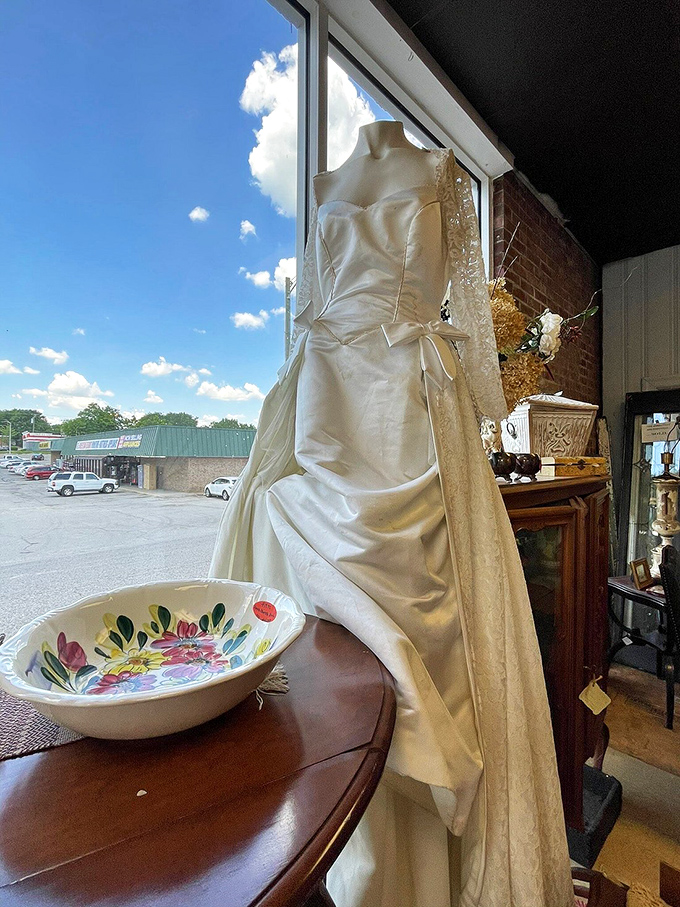 This vintage wedding dress stands sentinel by the window, perhaps dreaming of its glory day when it walked down the aisle in an era of simpler celebrations.