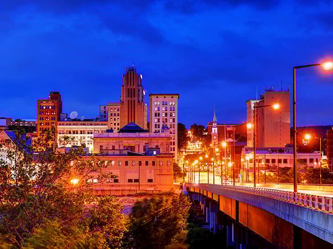 Youngstown’s skyline glows at twilight, historic buildings rising as an illuminated bridge welcomes you into the city.