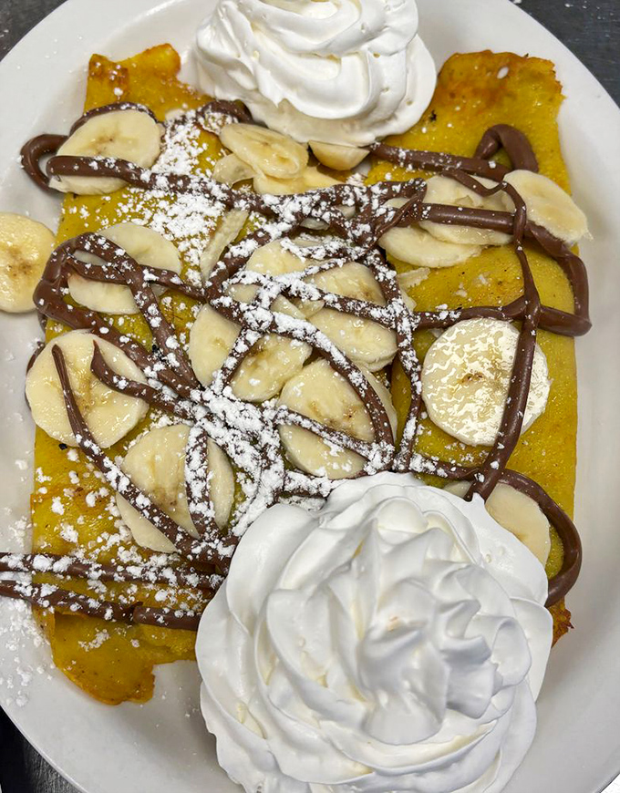 Banana and Nutella unite on golden crepes with generous dollops of whipped cream—a breakfast indulgence that makes Monday feel like Saturday.
