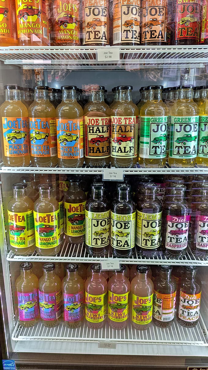 Joe's colorful beverage bottles line the cooler like liquid jewels. Peach tea, mango lemonade—each promising refreshment with a side of nostalgia.