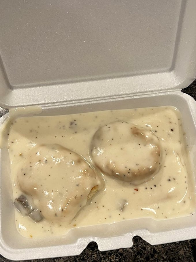 Biscuits swimming in gravy like they're enjoying a spa day. Southern comfort in styrofoam—practical, unpretentious, and perfect.