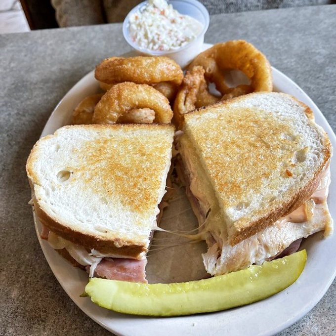 A sandwich that requires both hands and a strategy. Those onion rings aren't garnish—they're the perfect crunchy sidekick to this flavor bomb.