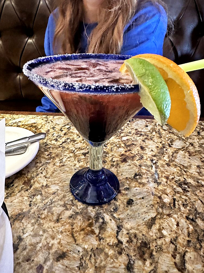 This isn't just a margarita—it's liquid jewelry. The salt-rimmed glass, vibrant color, and fresh garnishes promise a vacation in every sip.