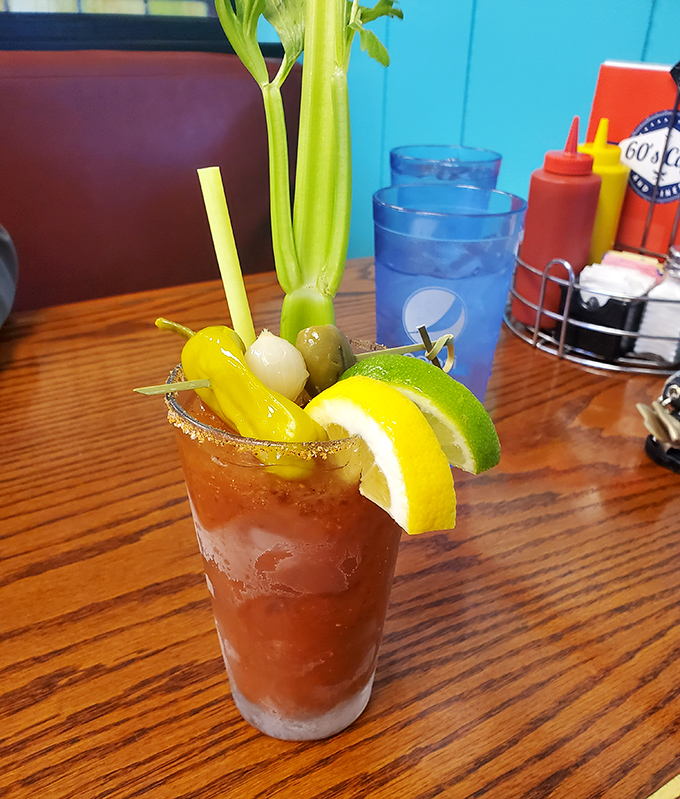 This Bloody Mary isn't just a drink – it's a garden party in a glass. The celery stalk stands tall like a lifeguard watching over all those delicious garnishes.