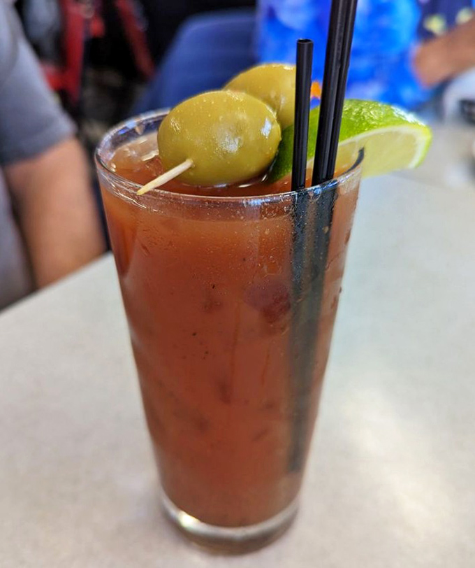 A Bloody Mary that means business, garnished with olives and lime—like a liquid salad that happens to contain vodka. Brunch in a glass.