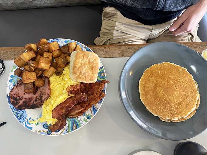 A breakfast platter that means business—golden home fries, farm-fresh eggs, crispy bacon, and a biscuit that could make your grandma jealous.