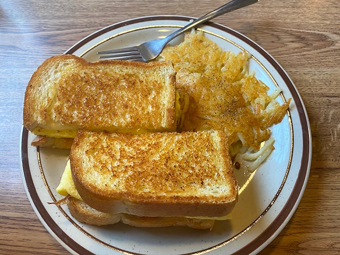 The humble grilled cheese, elevated to art form. Golden-brown perfection with hash browns that crackle with each bite—proof that simplicity, when done right, is revolutionary.