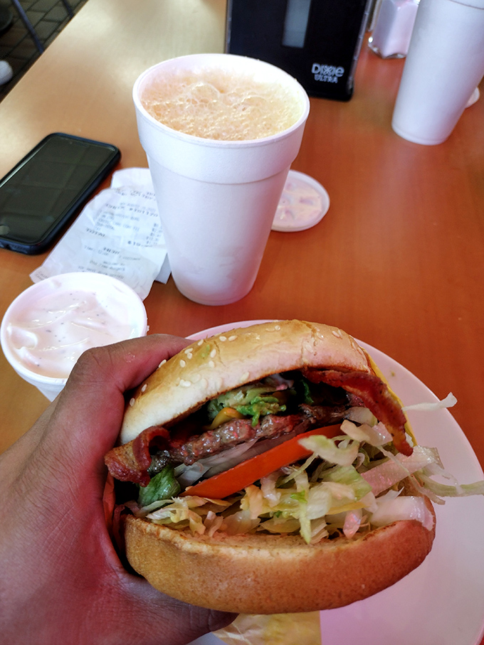 That milkshake isn't just a beverage—it's a commitment, standing tall beside a burger that's dressed for success with fresh lettuce and tomato.