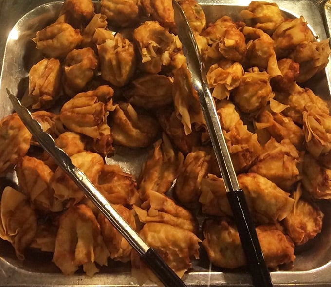 These golden-brown dumplings huddle together like old friends at a reunion, each one promising a perfect bite of savory filling wrapped in crispy goodness.
