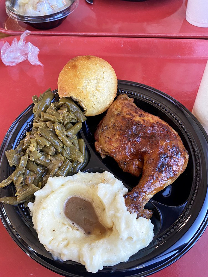 The Southern trifecta: perfectly seasoned fried chicken, greens swimming in pot likker, and mashed potatoes with a gravy divot deep enough to dive into.