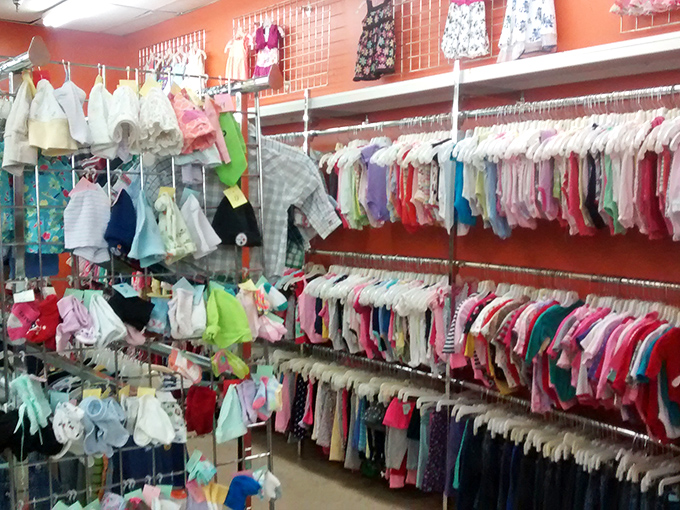 The children's clothing section bursts with tiny fashions, where onesies and sundresses hang like colorful flags of childhood's fleeting moments.