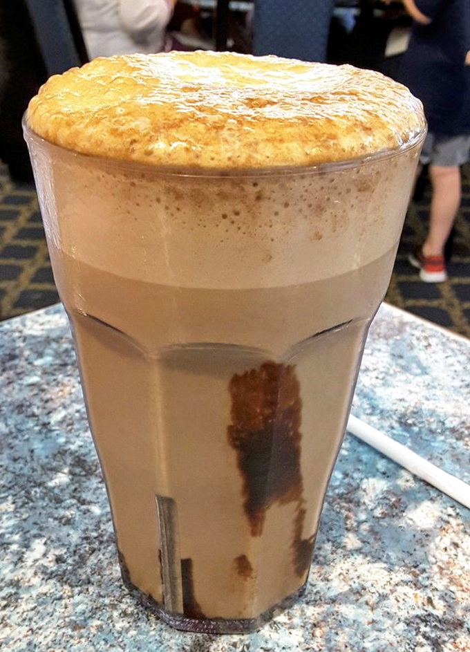 The chocolate egg cream rises majestically in its glass—a frothy, nostalgic concoction that whispers sweet nothings to your inner child.