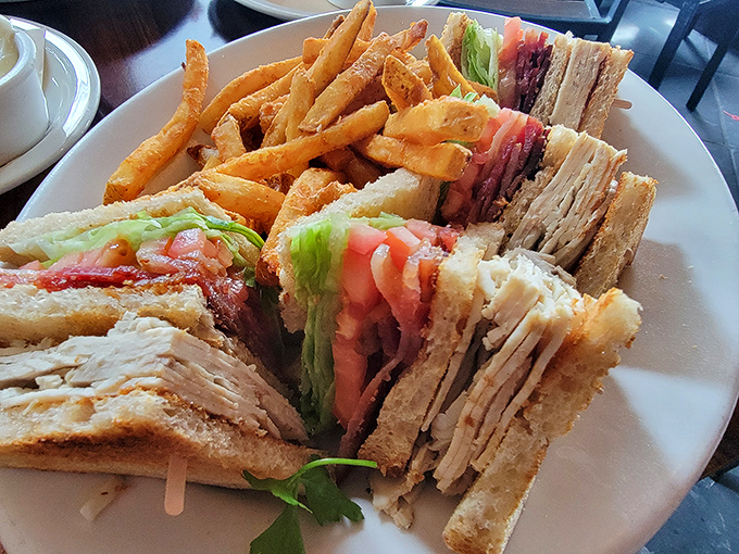 The club sandwich: mankind's most perfect food invention. This triple-decker masterpiece with crisp fries might require unhinging your jaw.