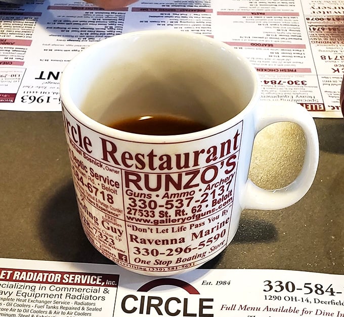 The coffee mug doubles as local advertising real estate—because in small-town Ohio, your caffeine fix comes with community connections.