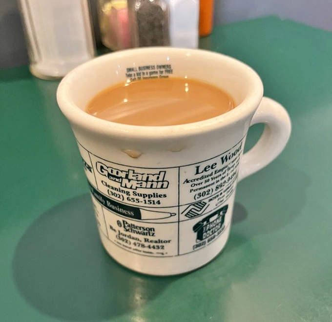 The coffee comes in mugs advertising local businesses—because in a place this authentic, even the cups tell stories about the community.